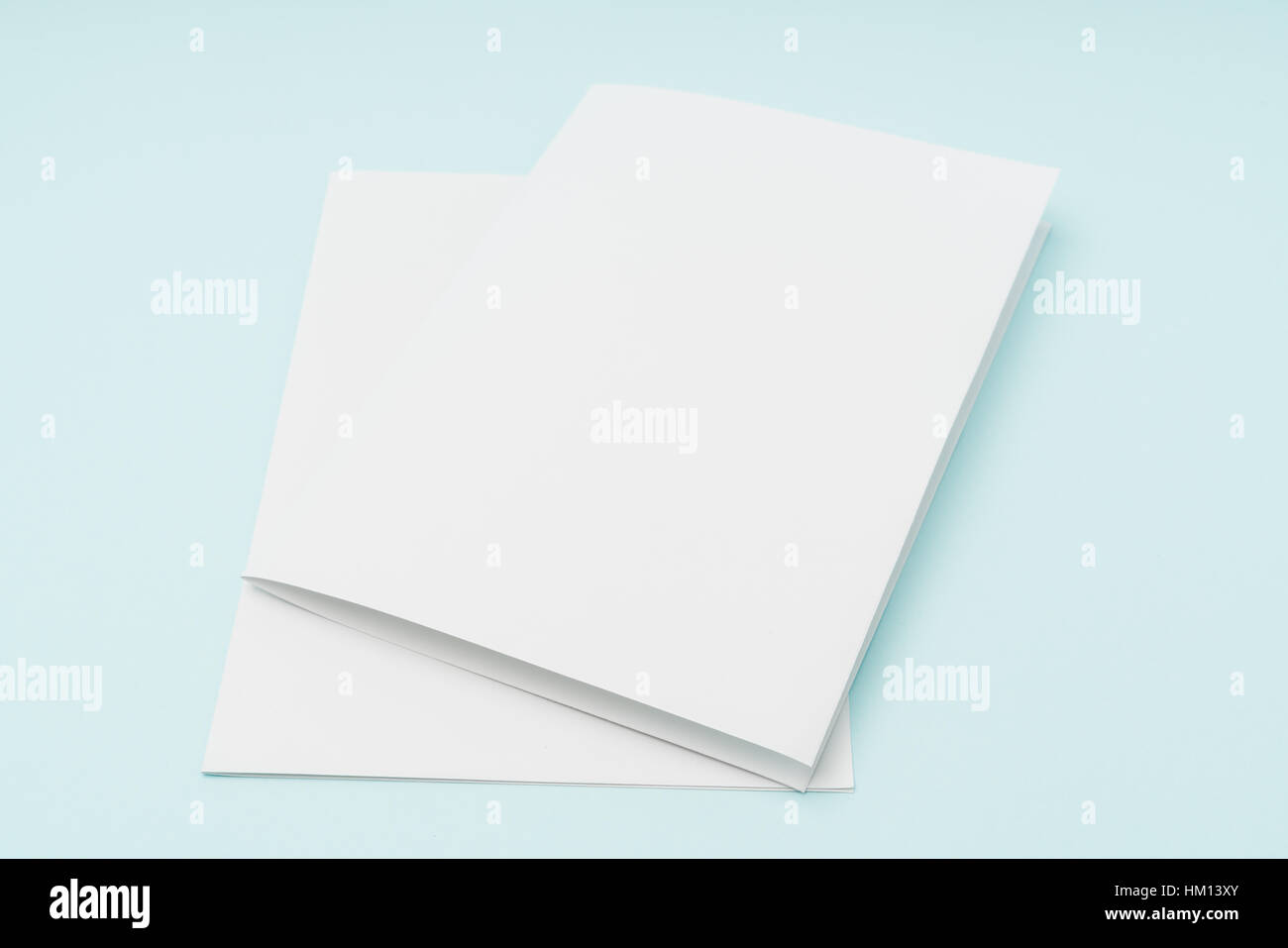 Bifold white template paper on blue background Stock Photo - Alamy
