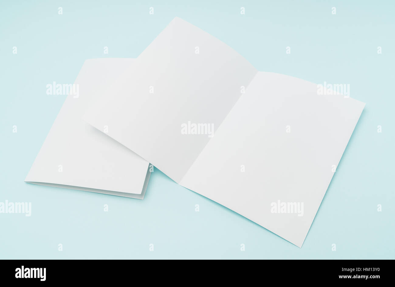 Bifold white template paper on blue background Stock Photo - Alamy