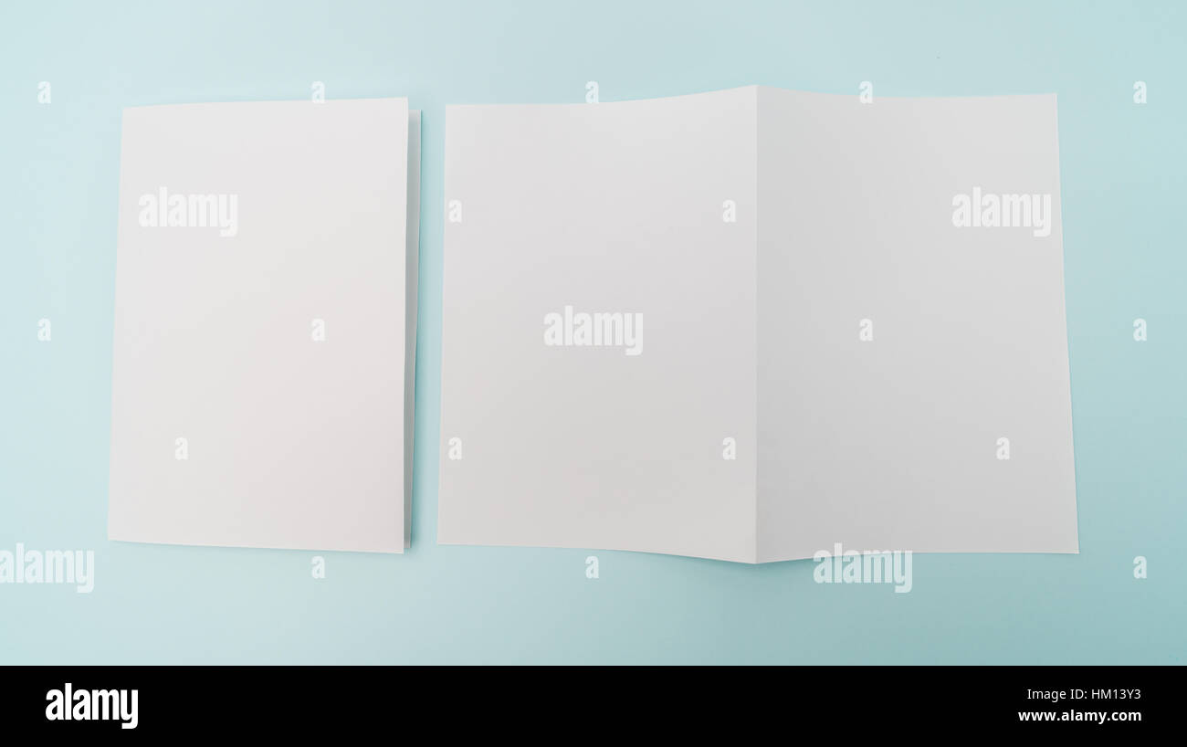 Bifold white template paper on blue background Stock Photo - Alamy