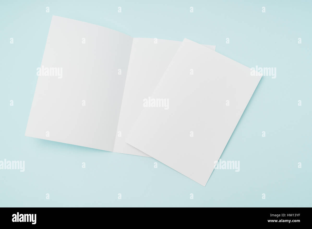 Bifold white template paper on blue background Stock Photo - Alamy
