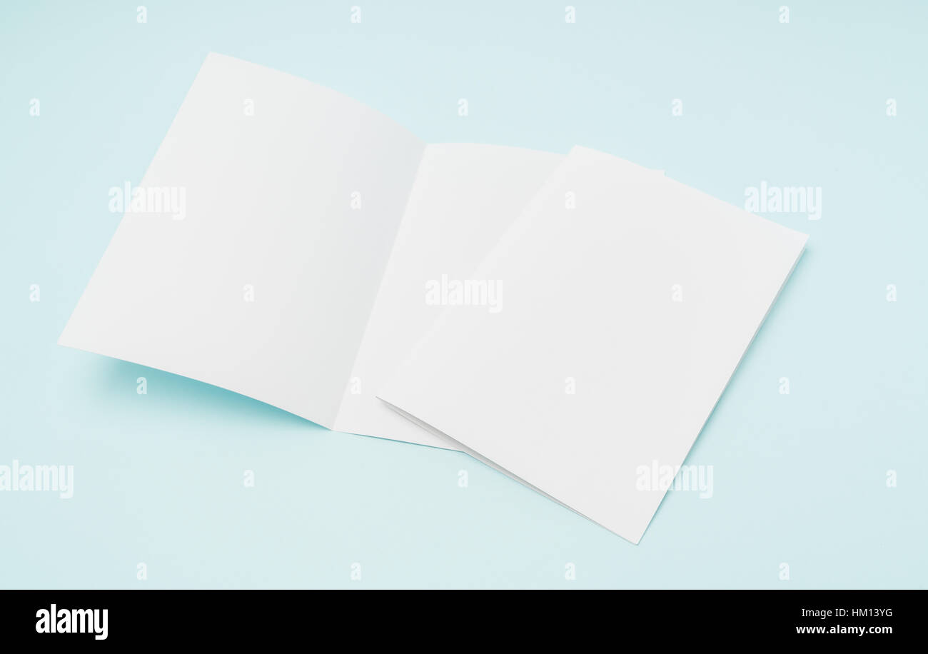 Bifold white template paper on blue background Stock Photo - Alamy
