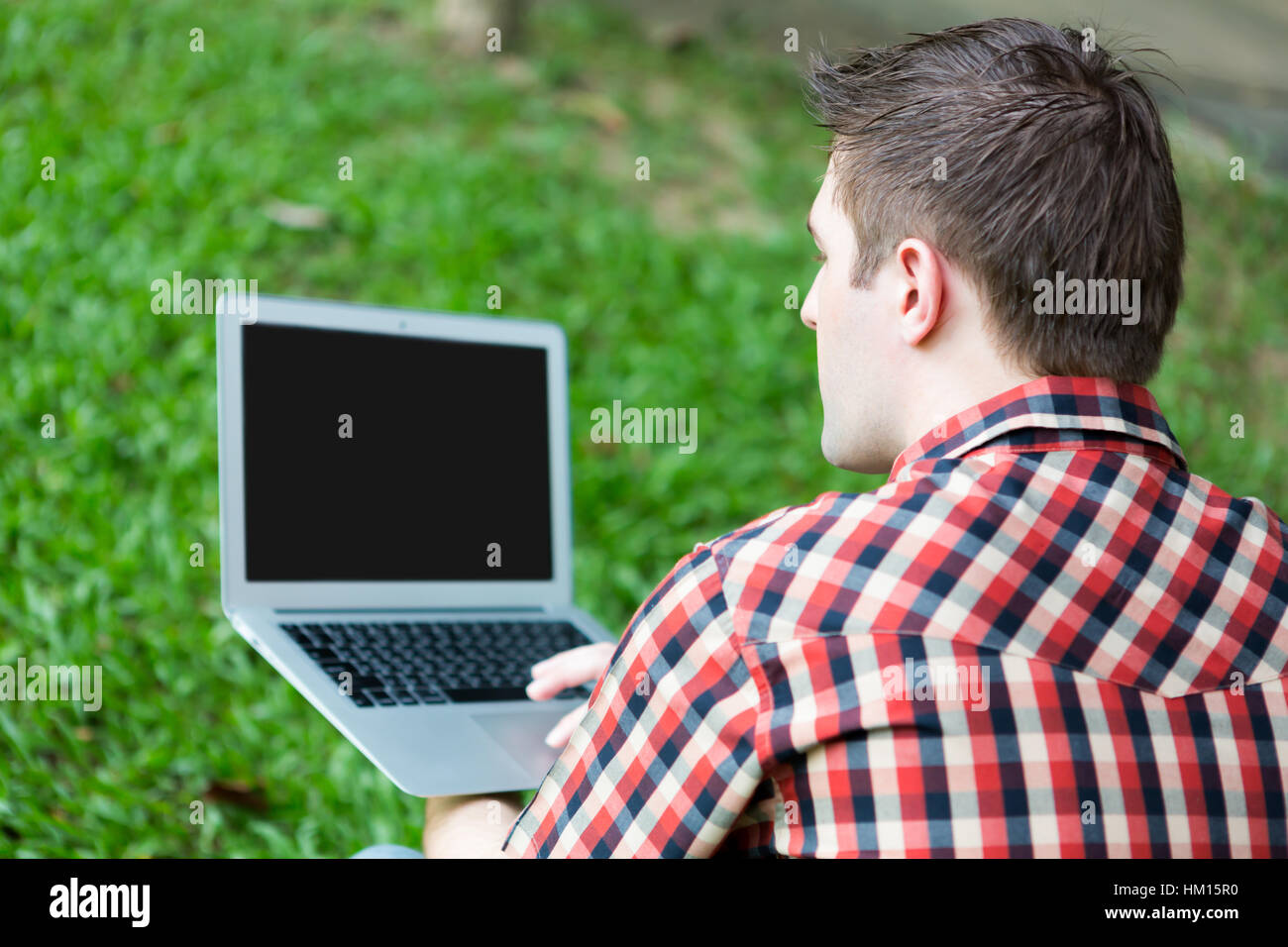 Portrait of young man with laptop outdoor Stock Photo - Alamy