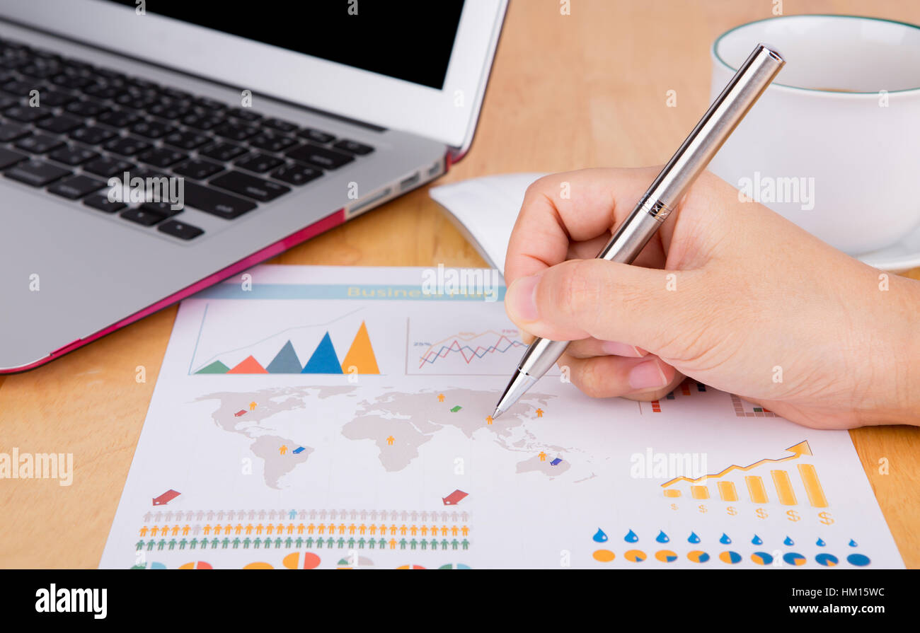 Hand write on financial chart on the table with laptop and coffee Stock ...