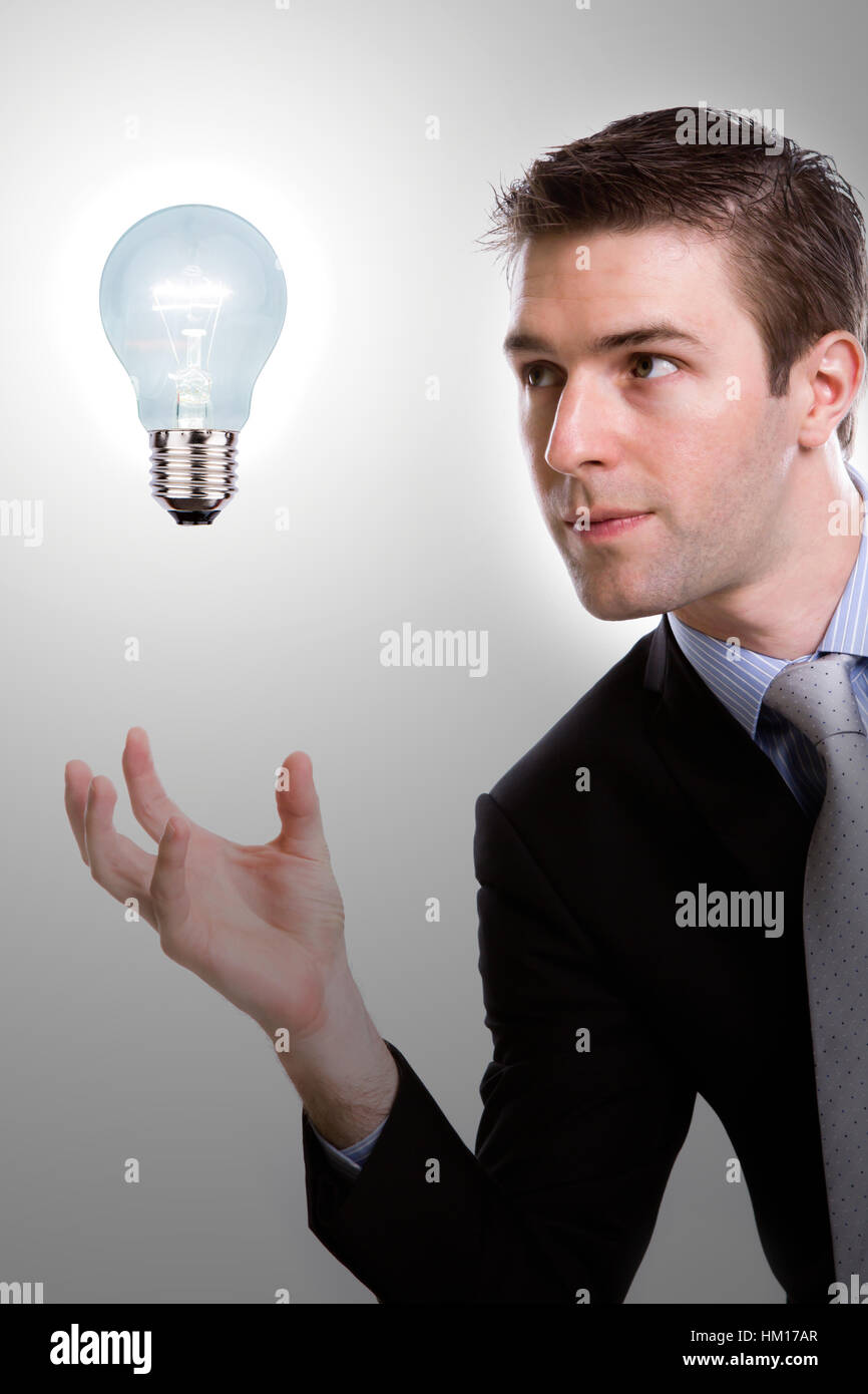 Portrait of young business man holding a light bulb Stock Photo - Alamy