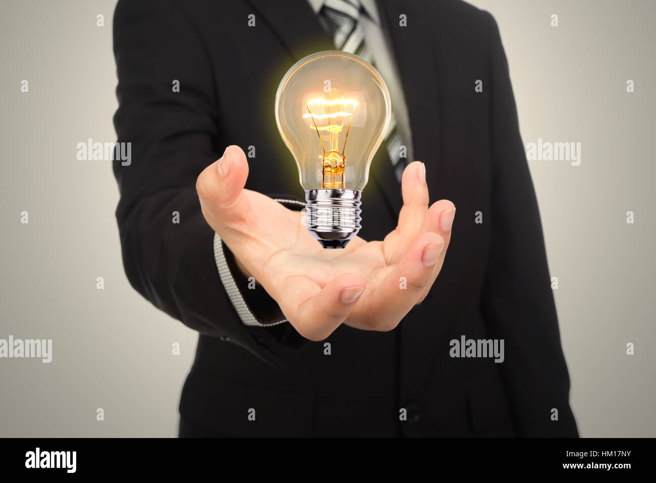 Business man holding light bulb Stock Photo - Alamy