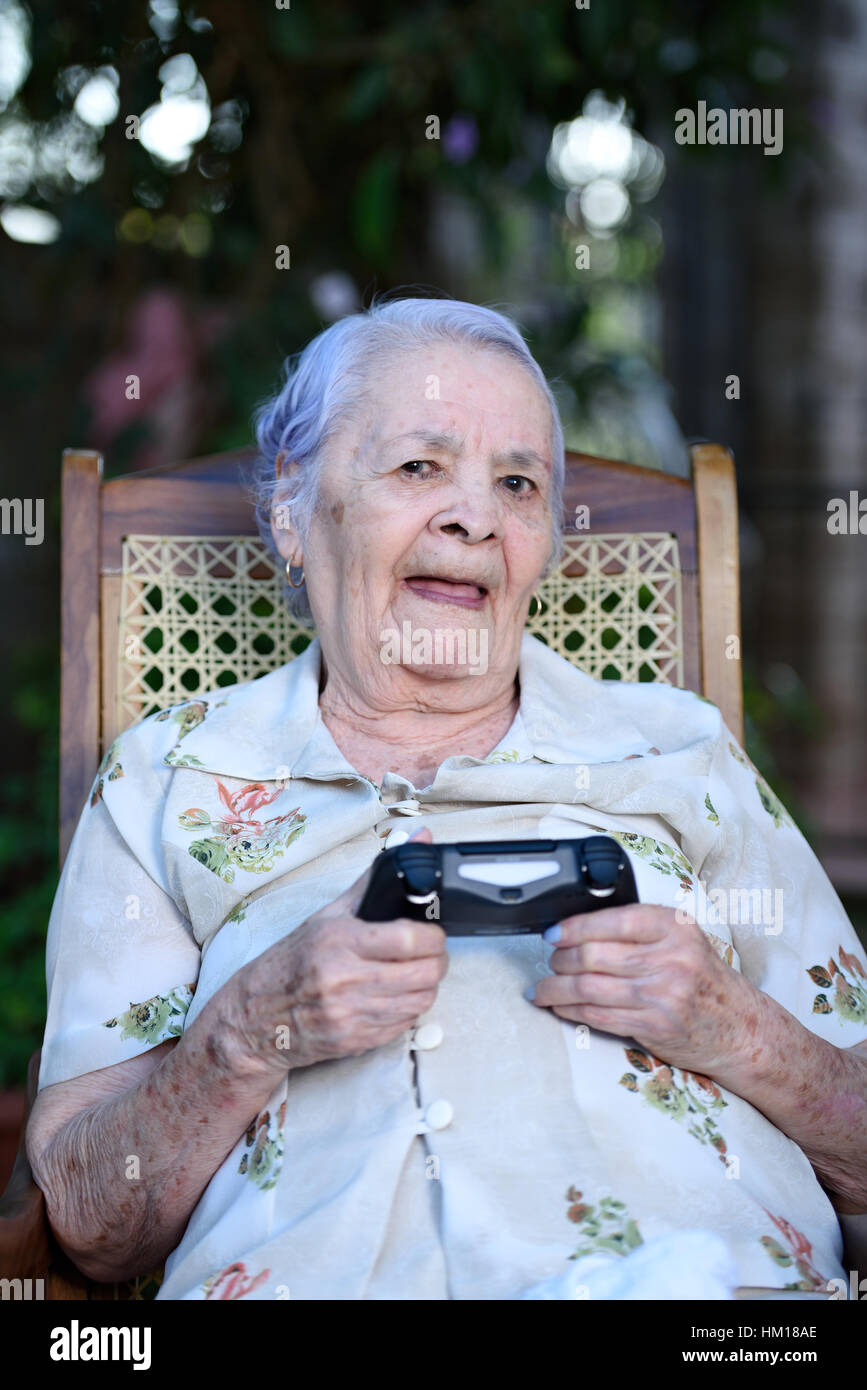 smiling grandma play videogames with wireless joystick Stock Photo - Alamy