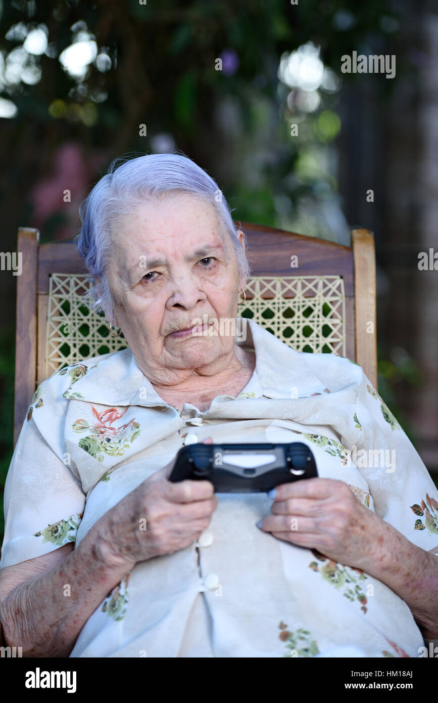 upset grandma with game joystick playing videogames Stock Photo - Alamy