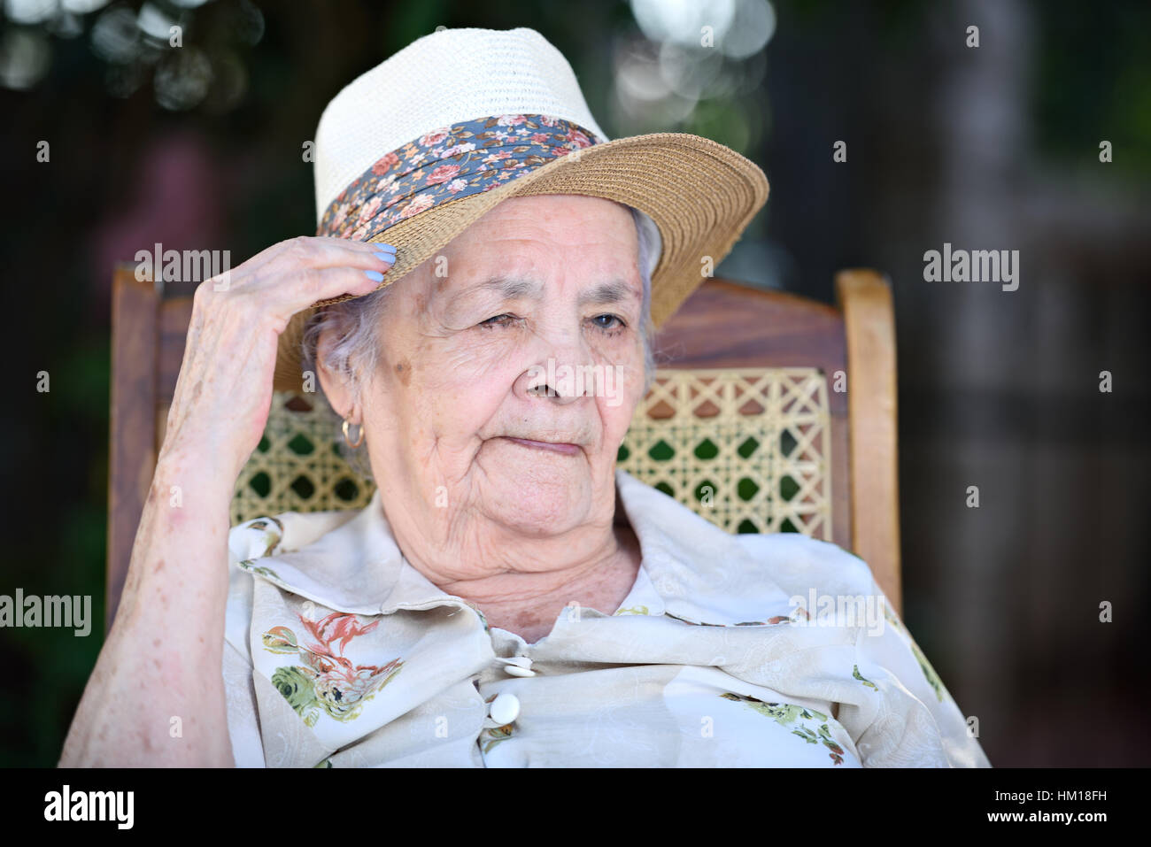 winking grandma with hat outside in park Stock Photo - Alamy