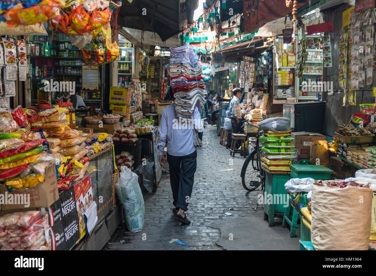 A man carrying a tower of fabrics through New Market (formerly known as ...