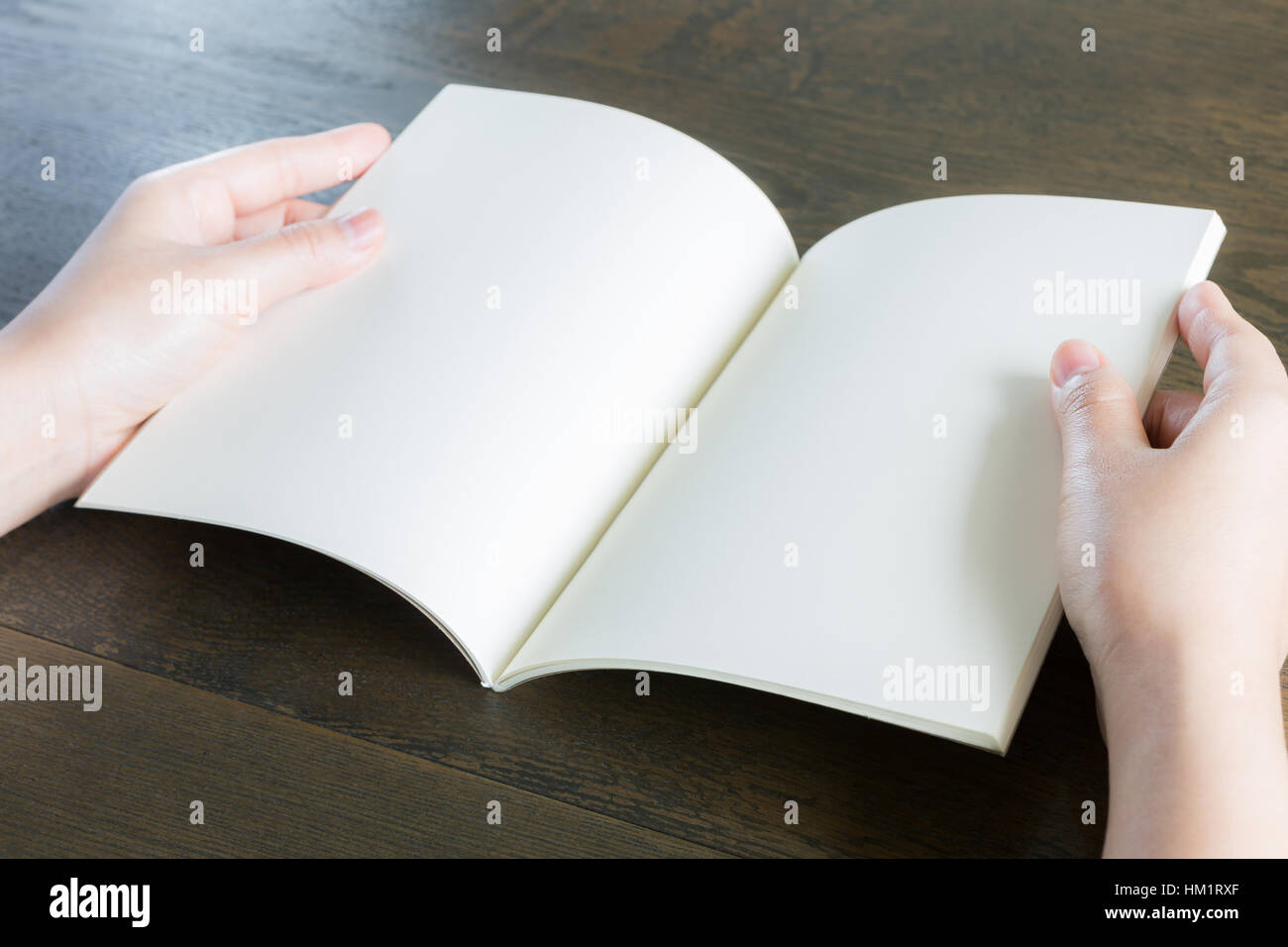 Hands open book on wood table Stock Photo - Alamy