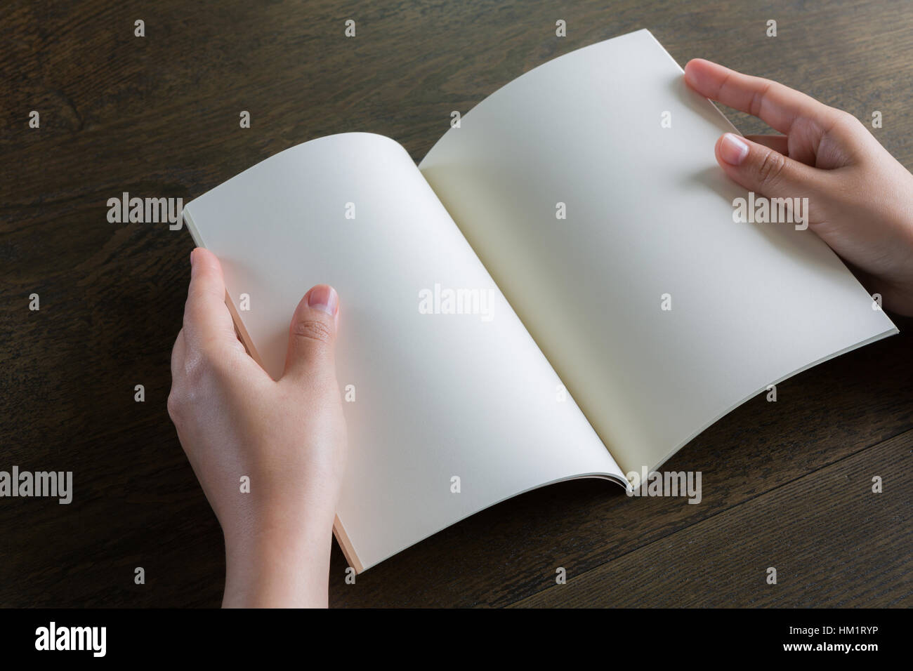 Hands open book on wood table Stock Photo - Alamy