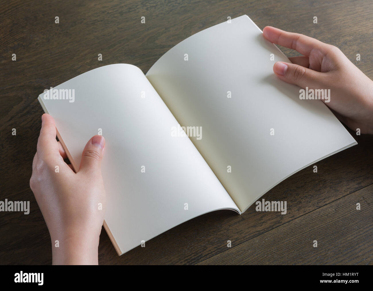 Hands open book on wood table Stock Photo - Alamy