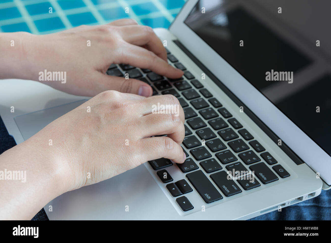 Woman working with laptop computer sitting at swimming pool Stock Photo ...