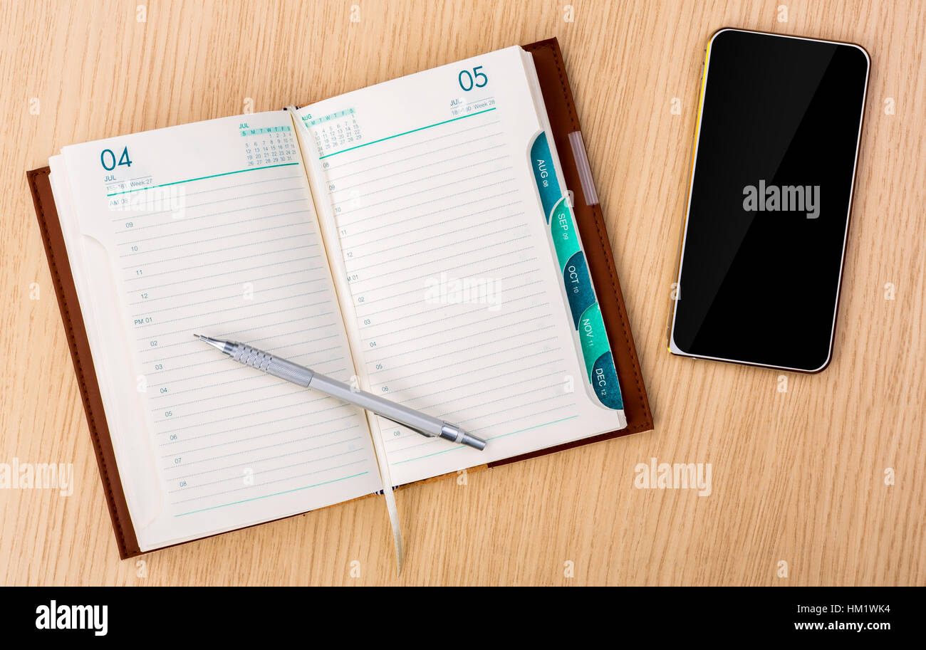 Modern mobile phone and Year business project planner book with pen on ...