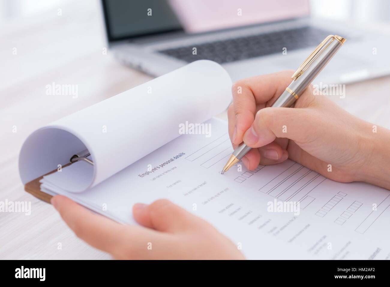 Hand with pen over application form Stock Photo - Alamy