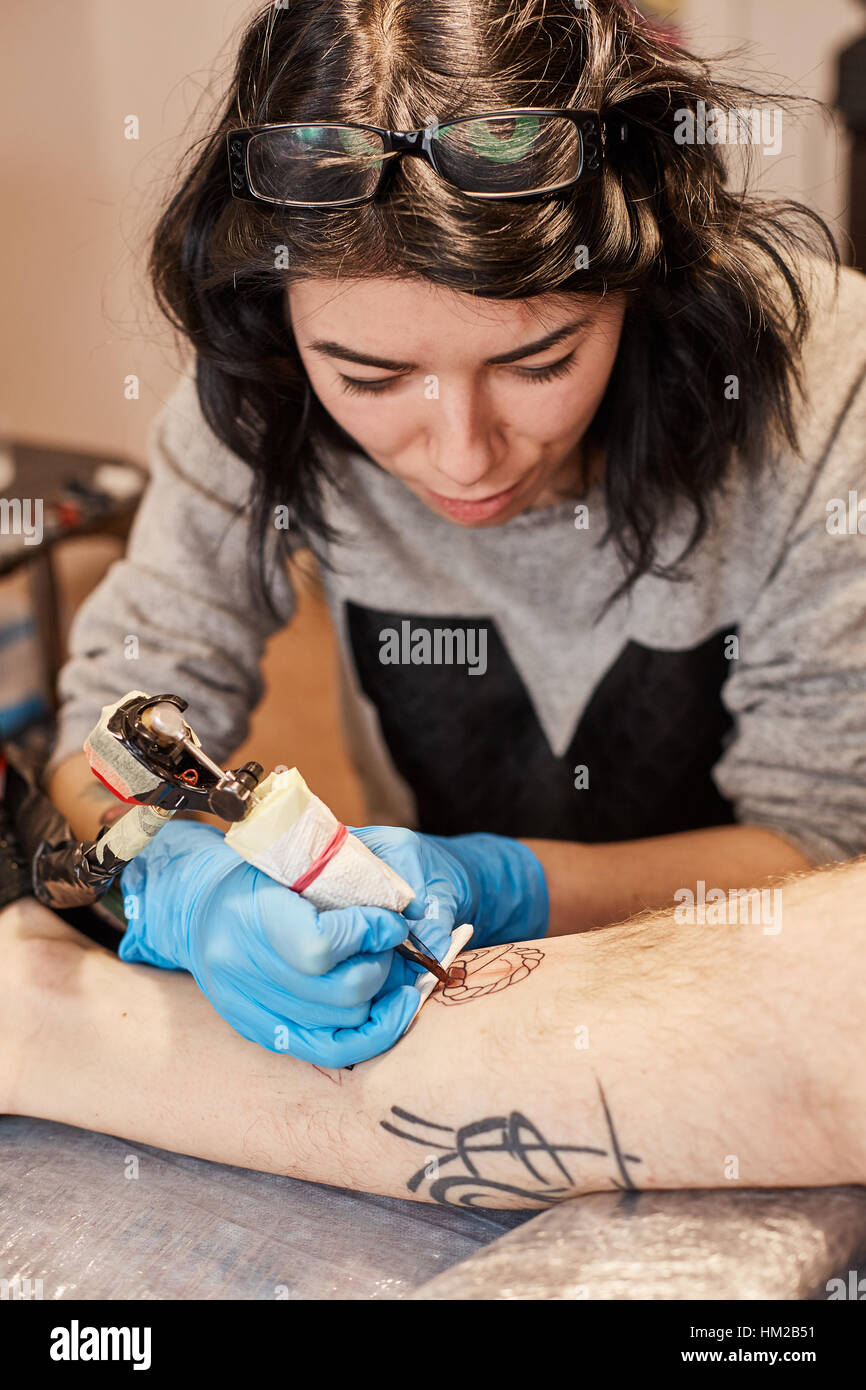 Tattoo artist is making tattoo Stock Photo - Alamy
