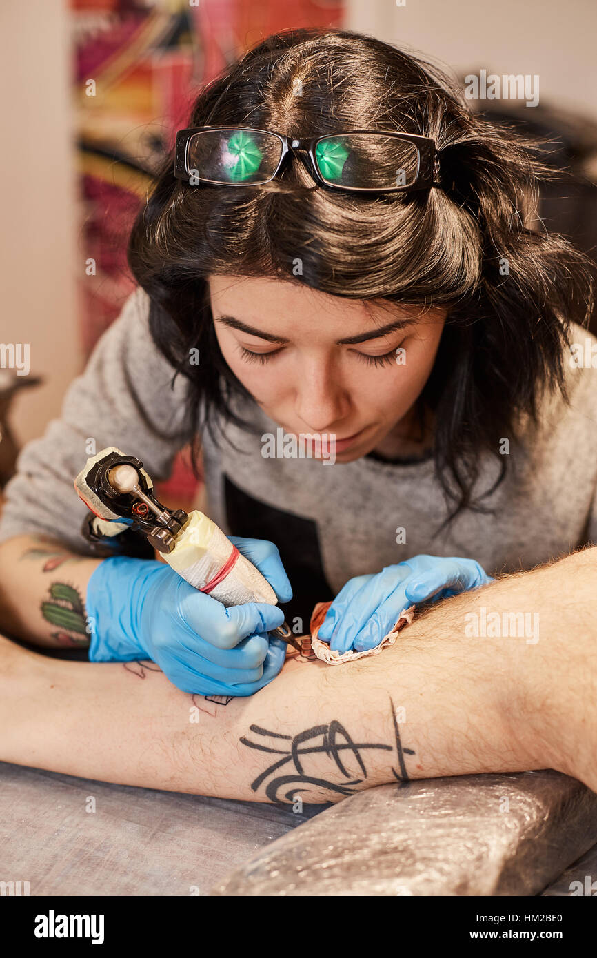 Tattoo artist is making Stock Photo - Alamy