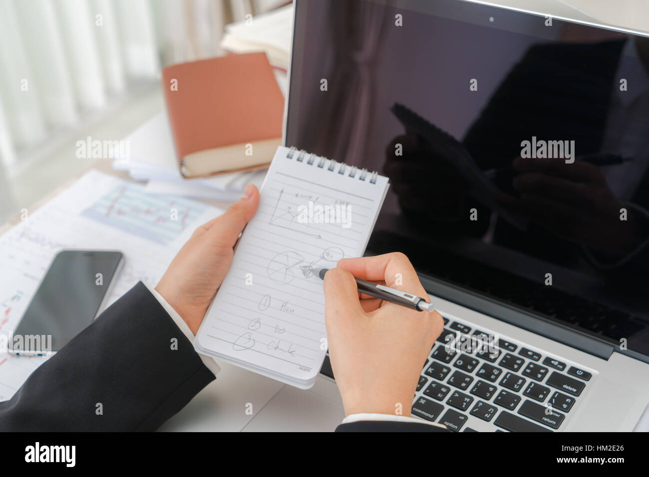 Business people using a pencil noting over laptop Stock Photo - Alamy