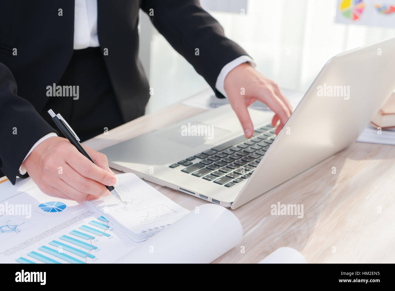 Business people using a pencil noting over laptop Stock Photo - Alamy