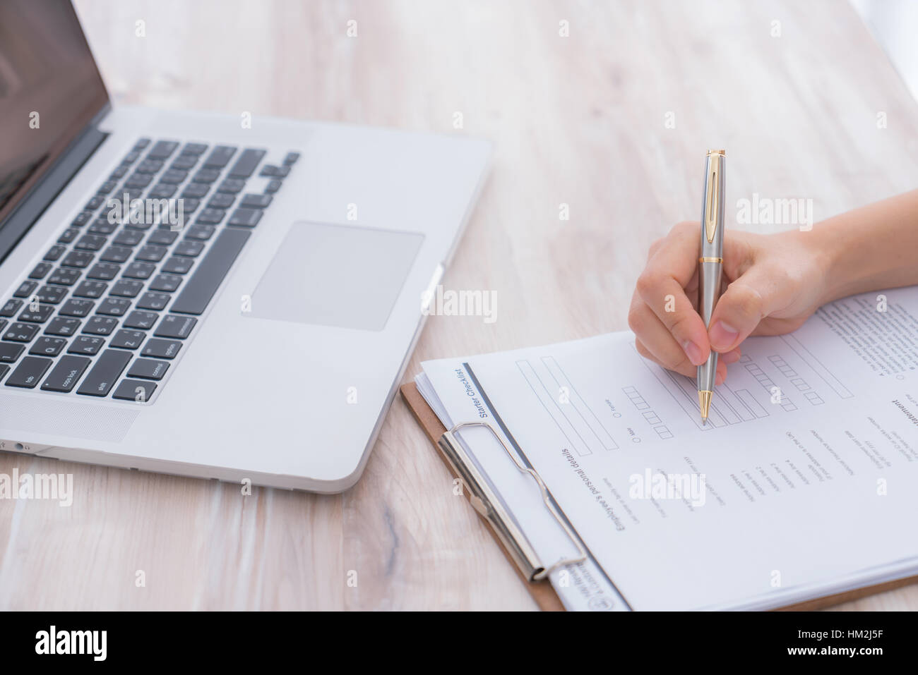 Hand with pen over application form Stock Photo - Alamy