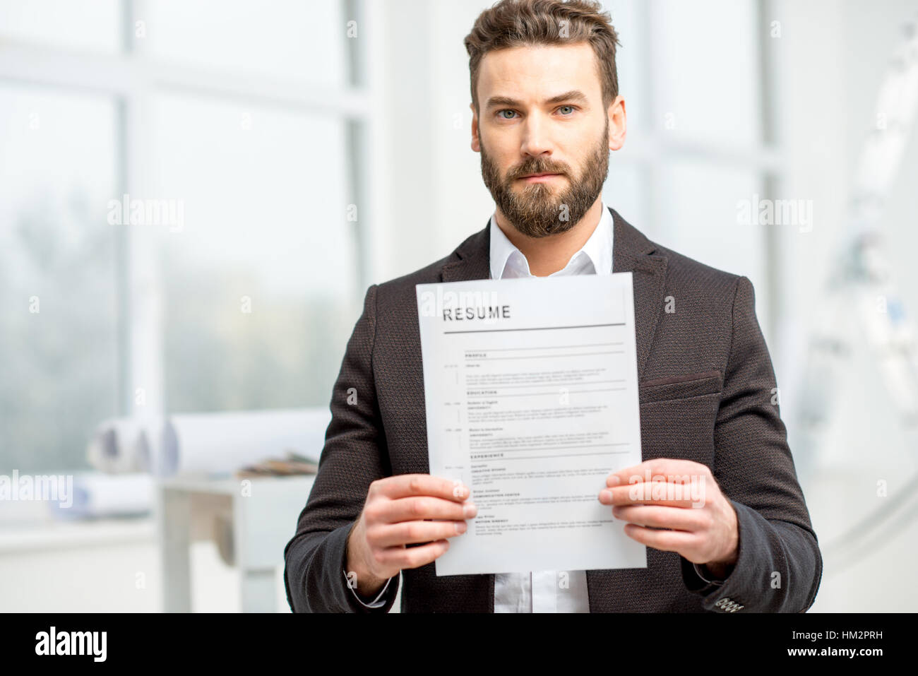 Elegant man in the suit holding resume for job hiring in the bright ...