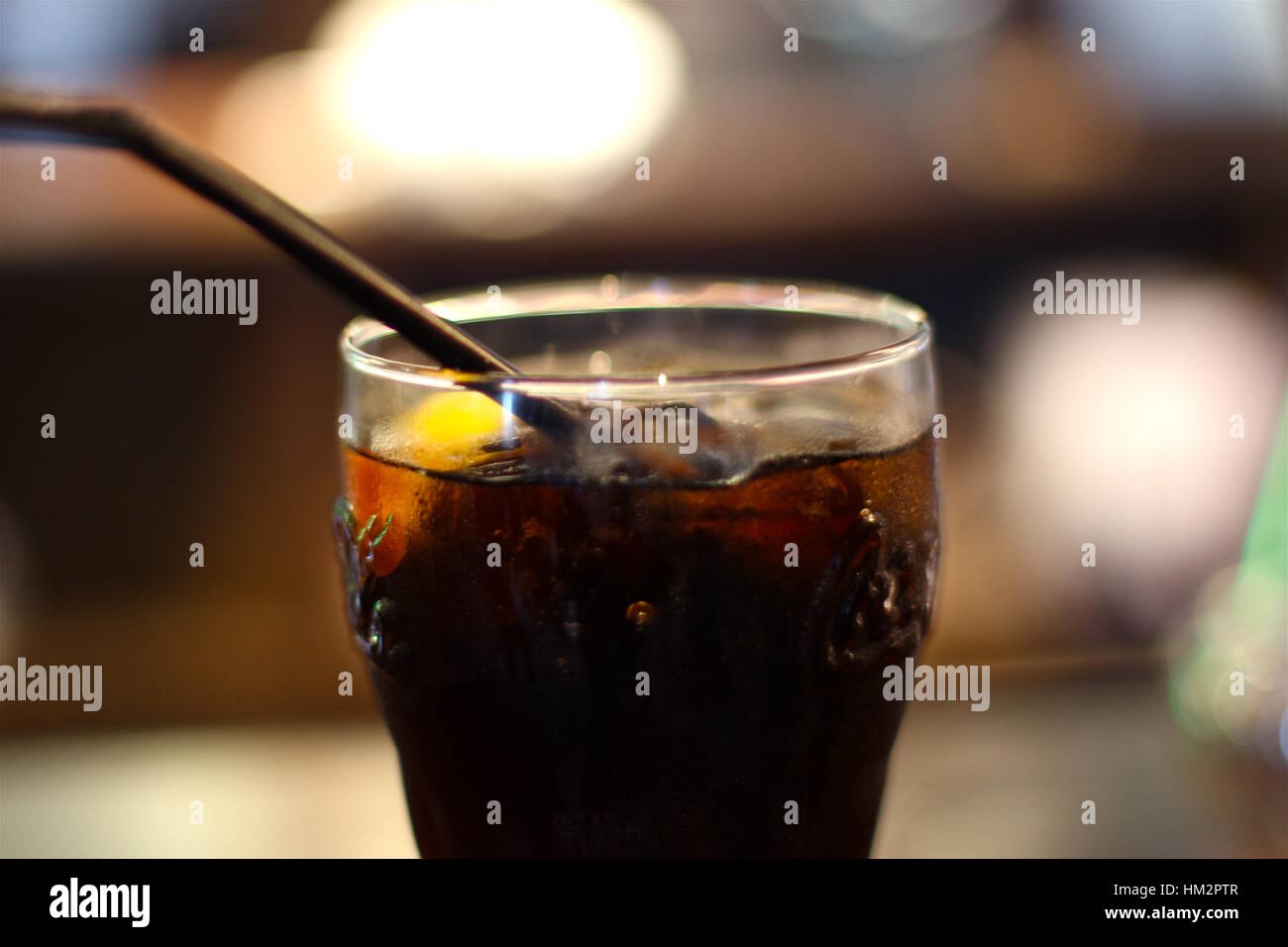 Coca Cola glass closeup. With a slice of lemon, ice cubes, and a black ...