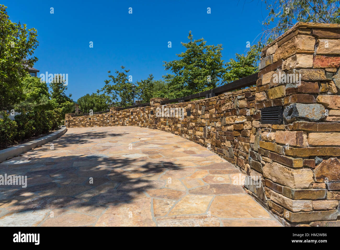 colorful path and stone wall with trees Stock Photo - Alamy