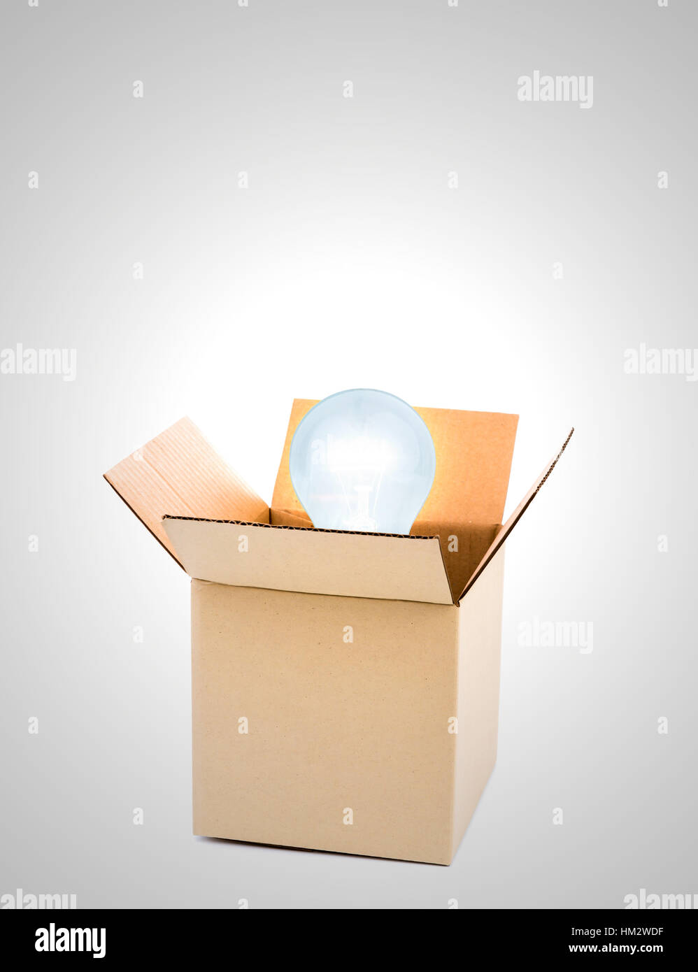 Glowing light bulb over open cardboard box Stock Photo - Alamy