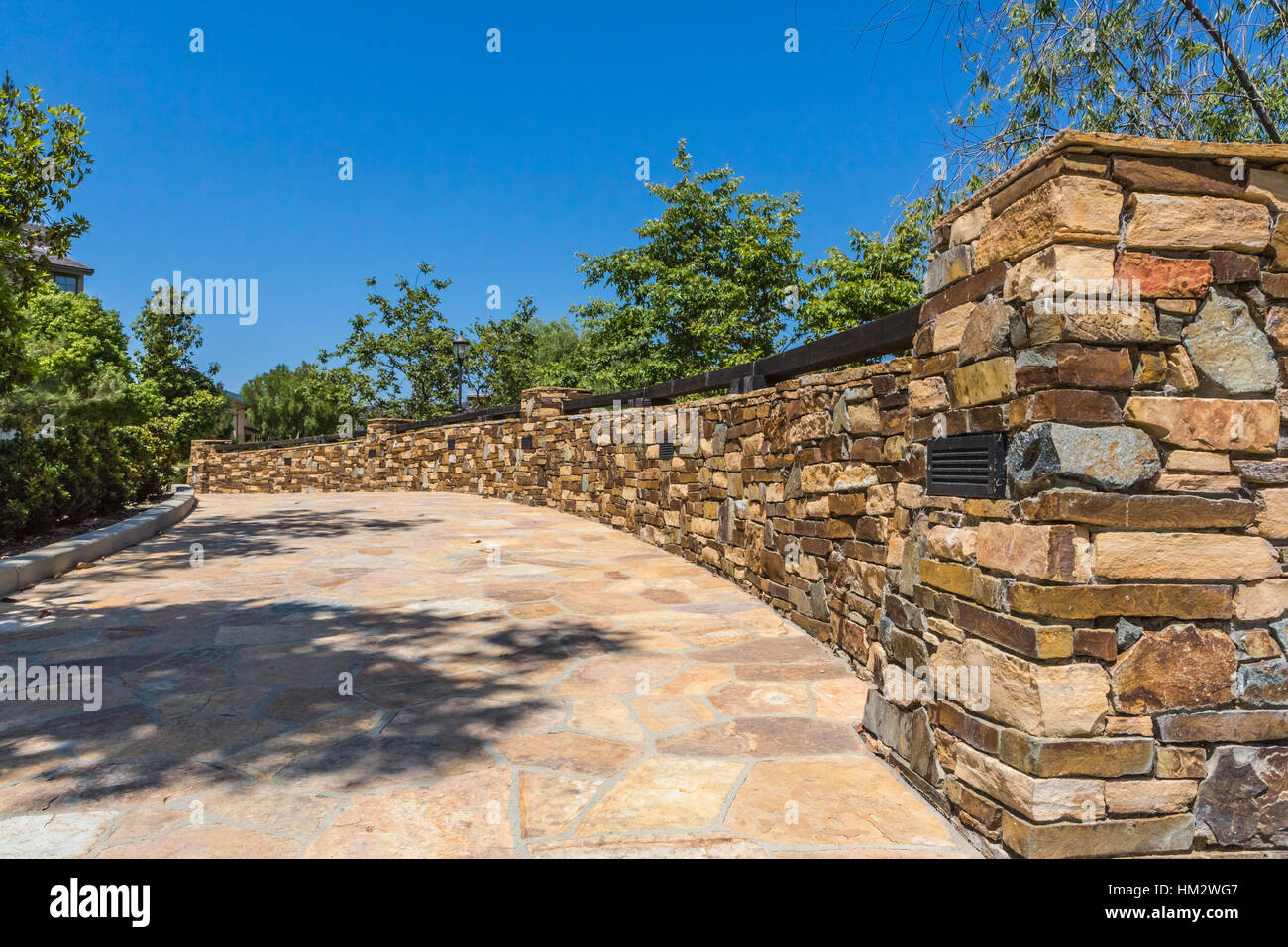 colorful path and stone wall with trees Stock Photo - Alamy