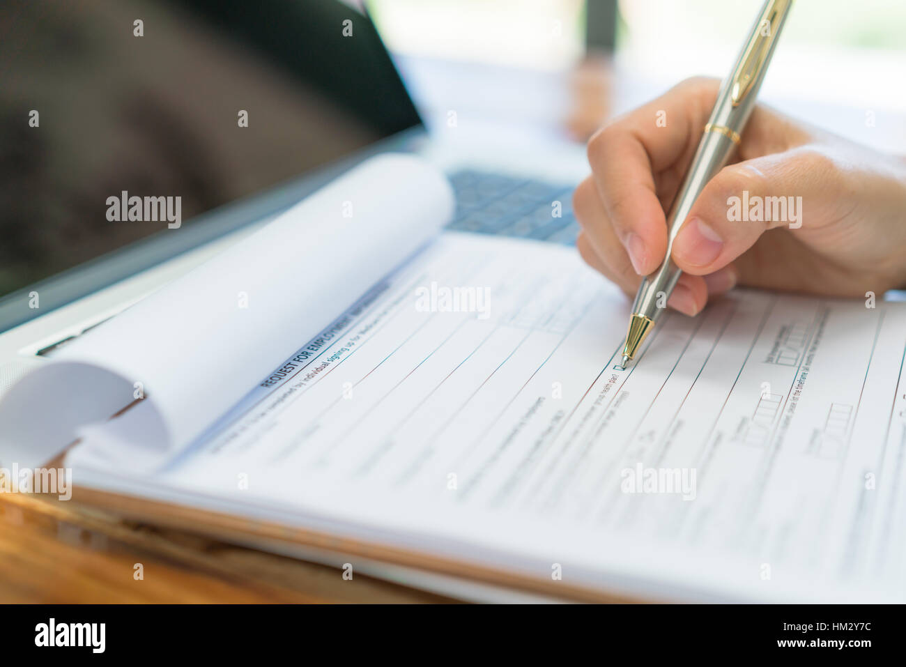 Hand with pen over application form Stock Photo - Alamy