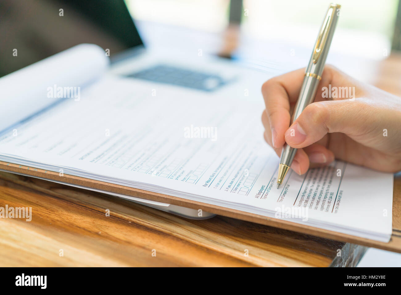 Hand with pen over application form Stock Photo - Alamy