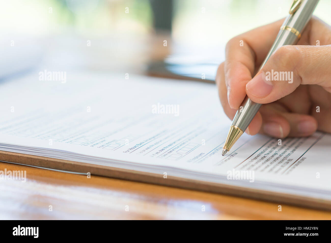 Hand with pen over application form Stock Photo - Alamy
