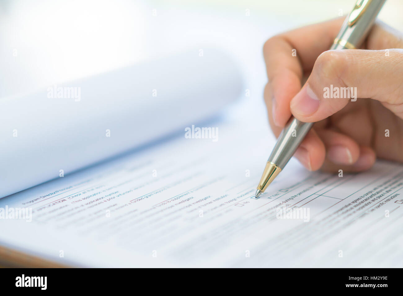 Hand with pen over application form Stock Photo - Alamy