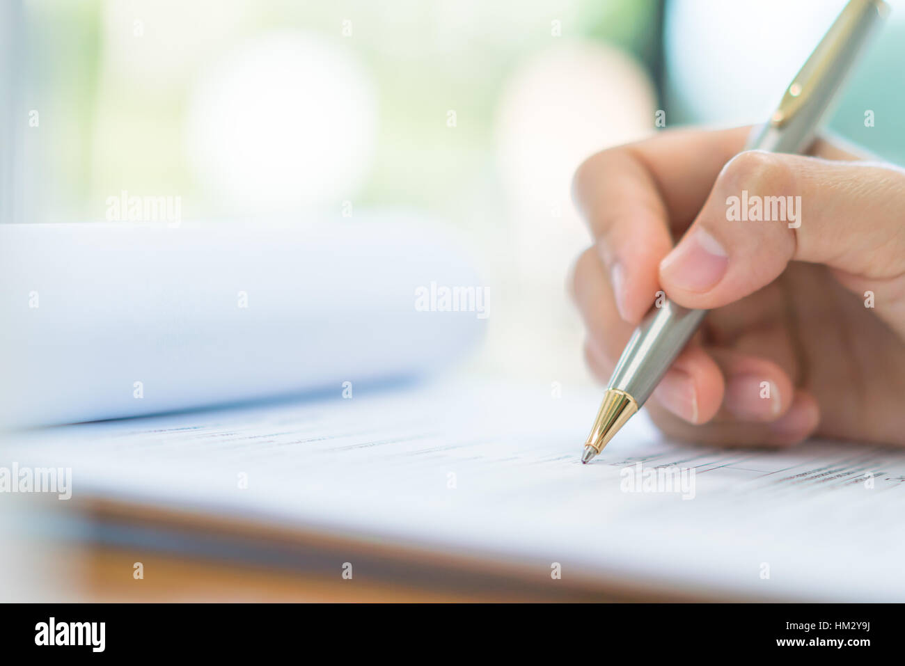 Hand with pen over application form Stock Photo - Alamy