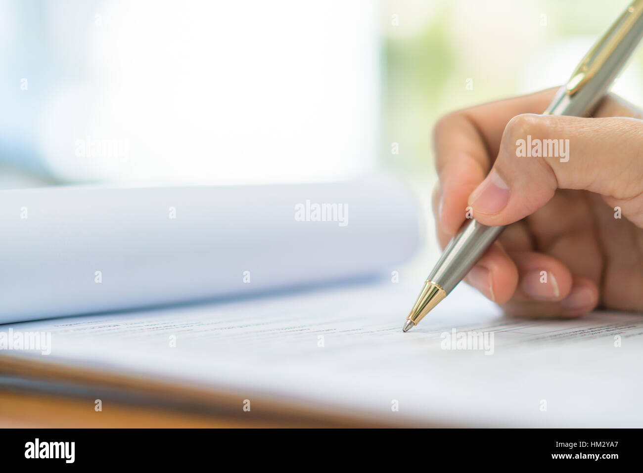Hand with pen over application form Stock Photo - Alamy