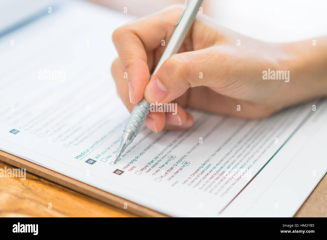 Hand with pen over application form Stock Photo - Alamy