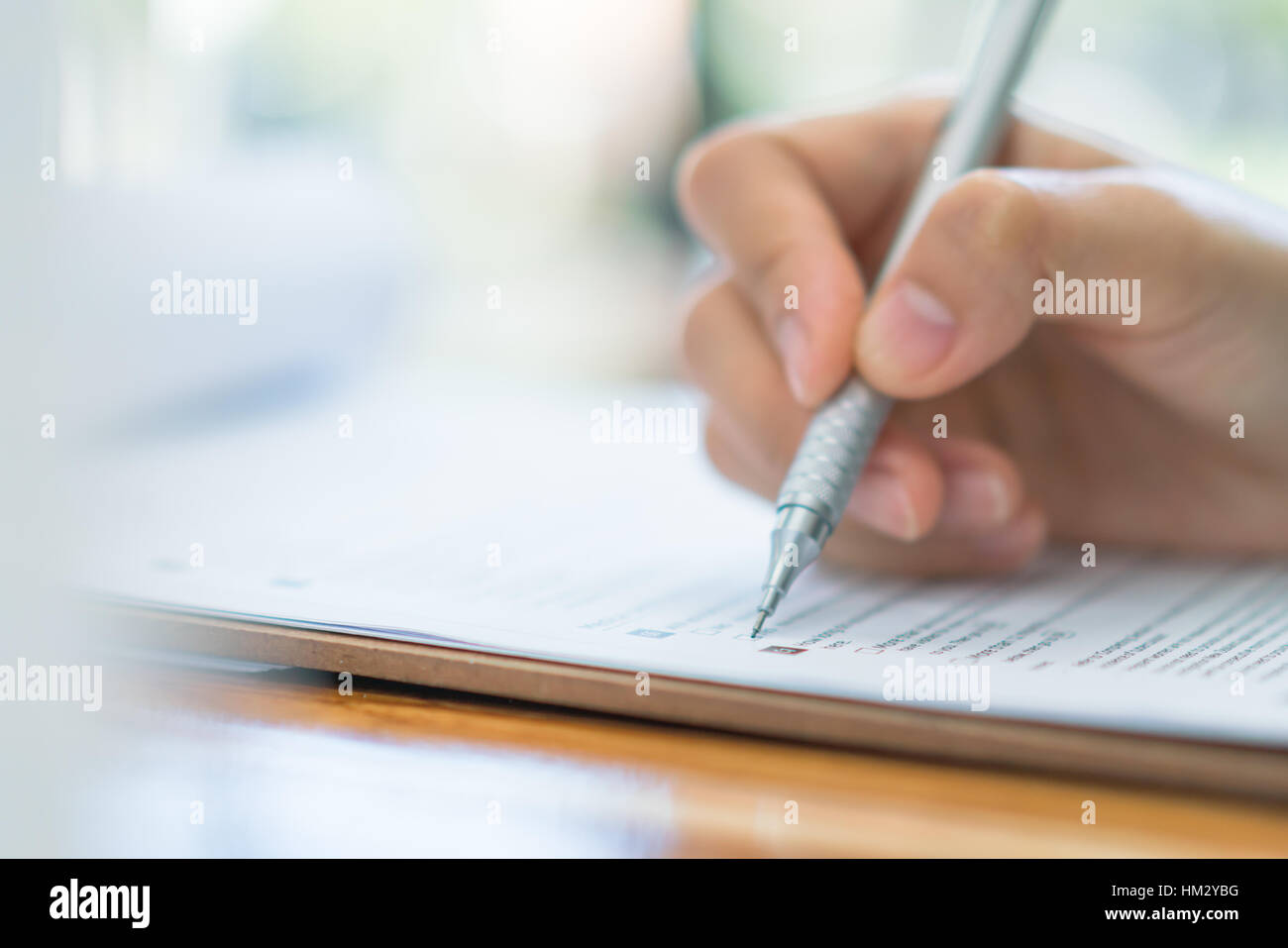 Hand with pen over application form Stock Photo - Alamy