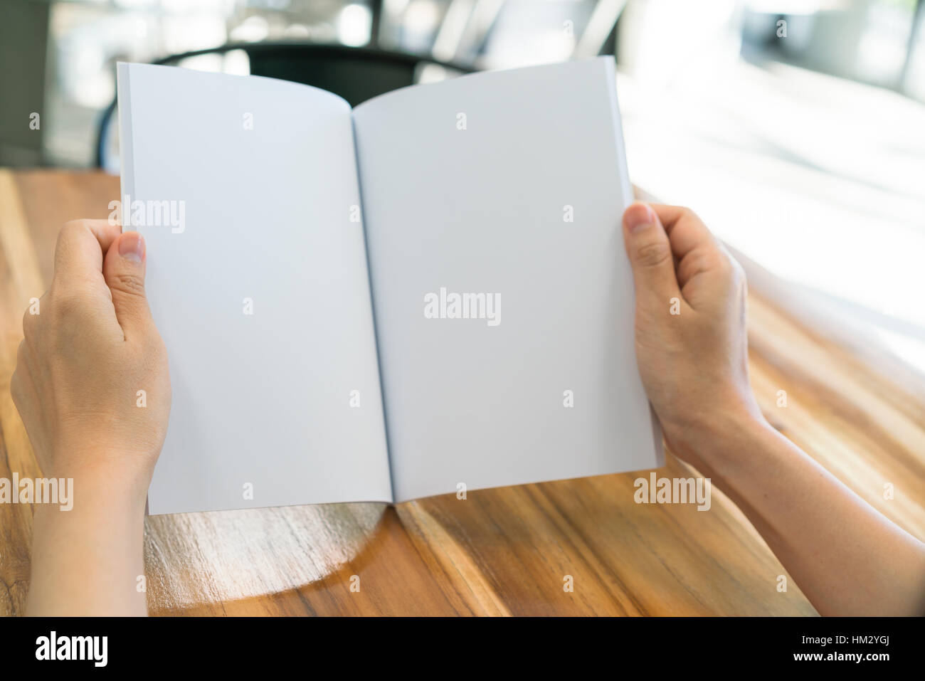 Hands open book on wood table Stock Photo - Alamy