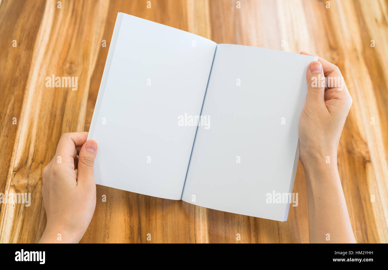 Hands open book on wood table Stock Photo - Alamy
