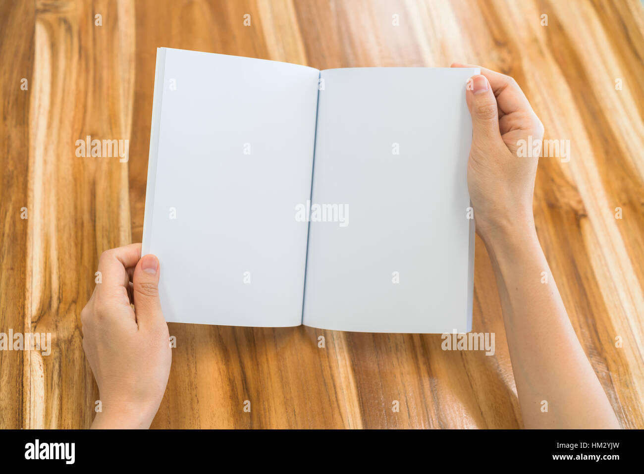 Hands open book on wood table Stock Photo - Alamy