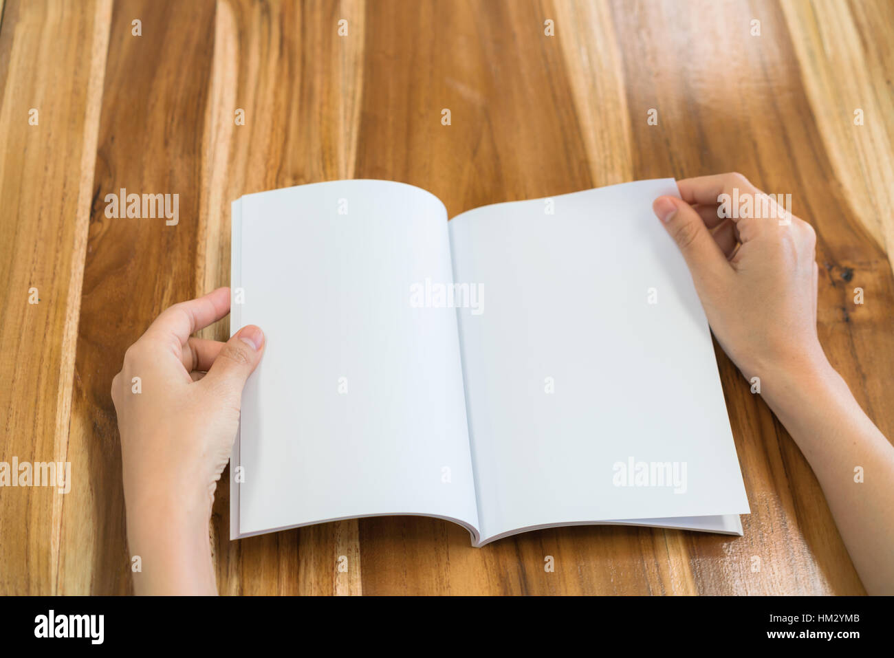 Hands open book on wood table Stock Photo - Alamy