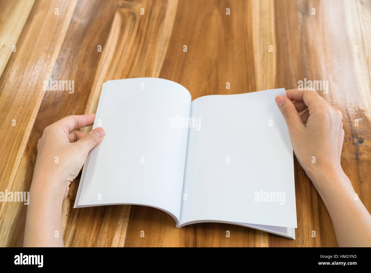 Hands open book on wood table Stock Photo - Alamy