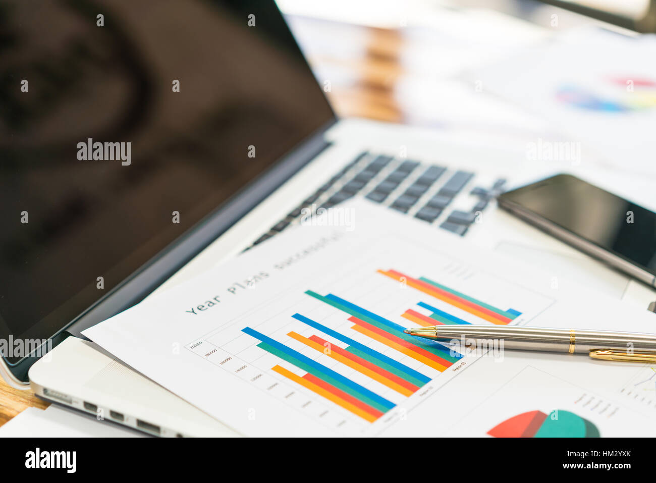 Financial charts on the table with laptop Stock Photo - Alamy