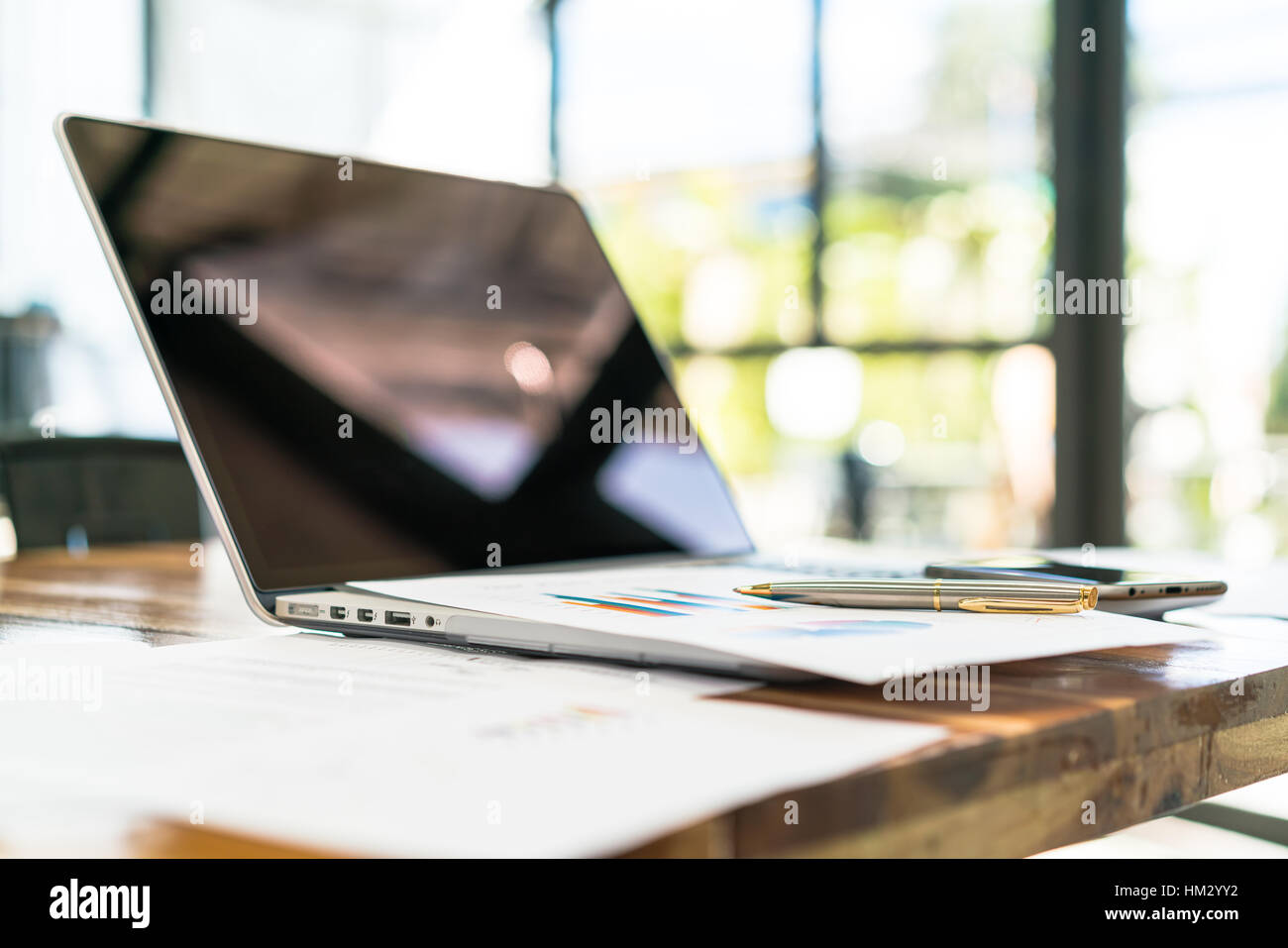 Financial charts on the table with laptop Stock Photo - Alamy