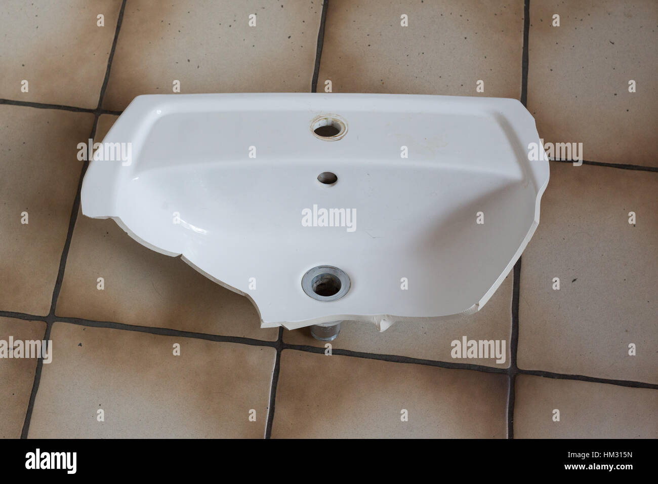 Destroyed washbasin on tile floor Stock Photo - Alamy
