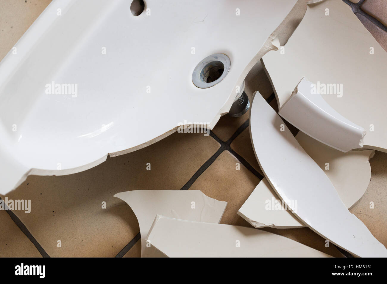 Destroyed washbasin on tile floor Stock Photo - Alamy