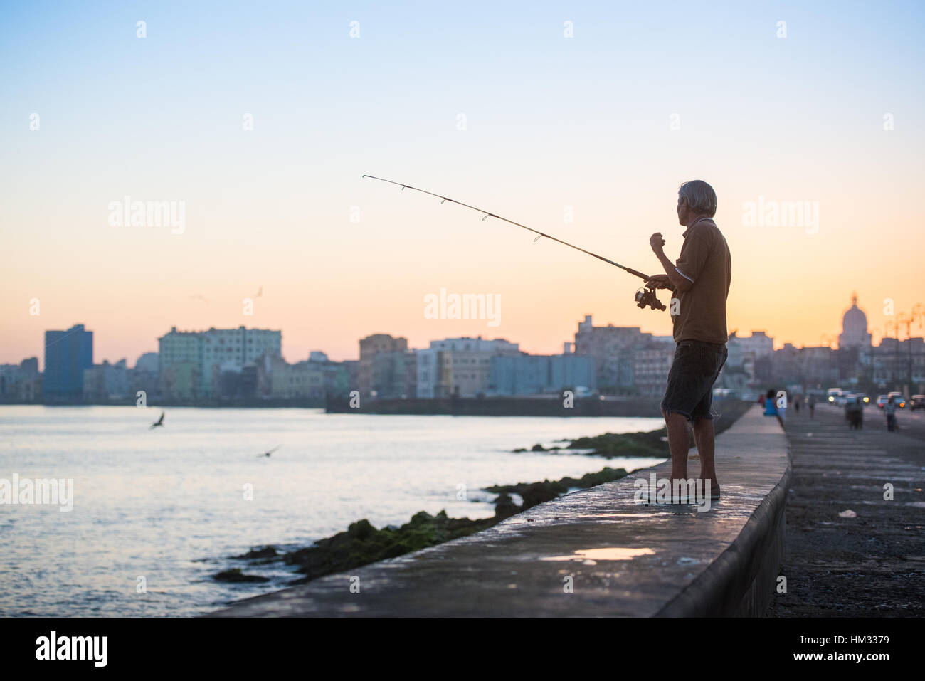 Cuban man fishing at sunrise on the Malecon in old Havana, Cuba Stock ...