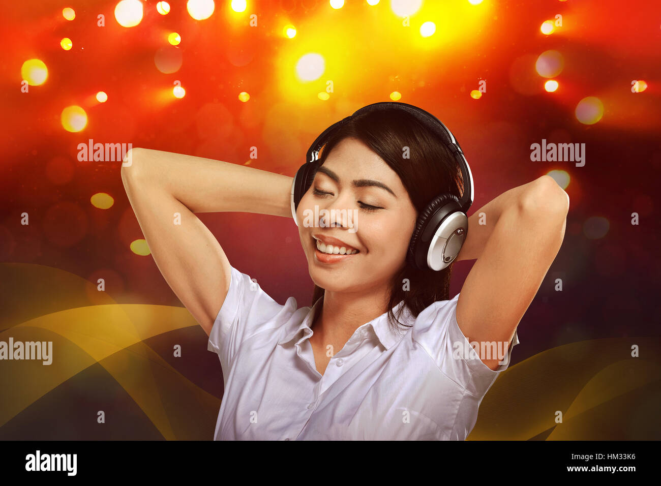 Young asian woman enjoying the music with headphone on blurred ...
