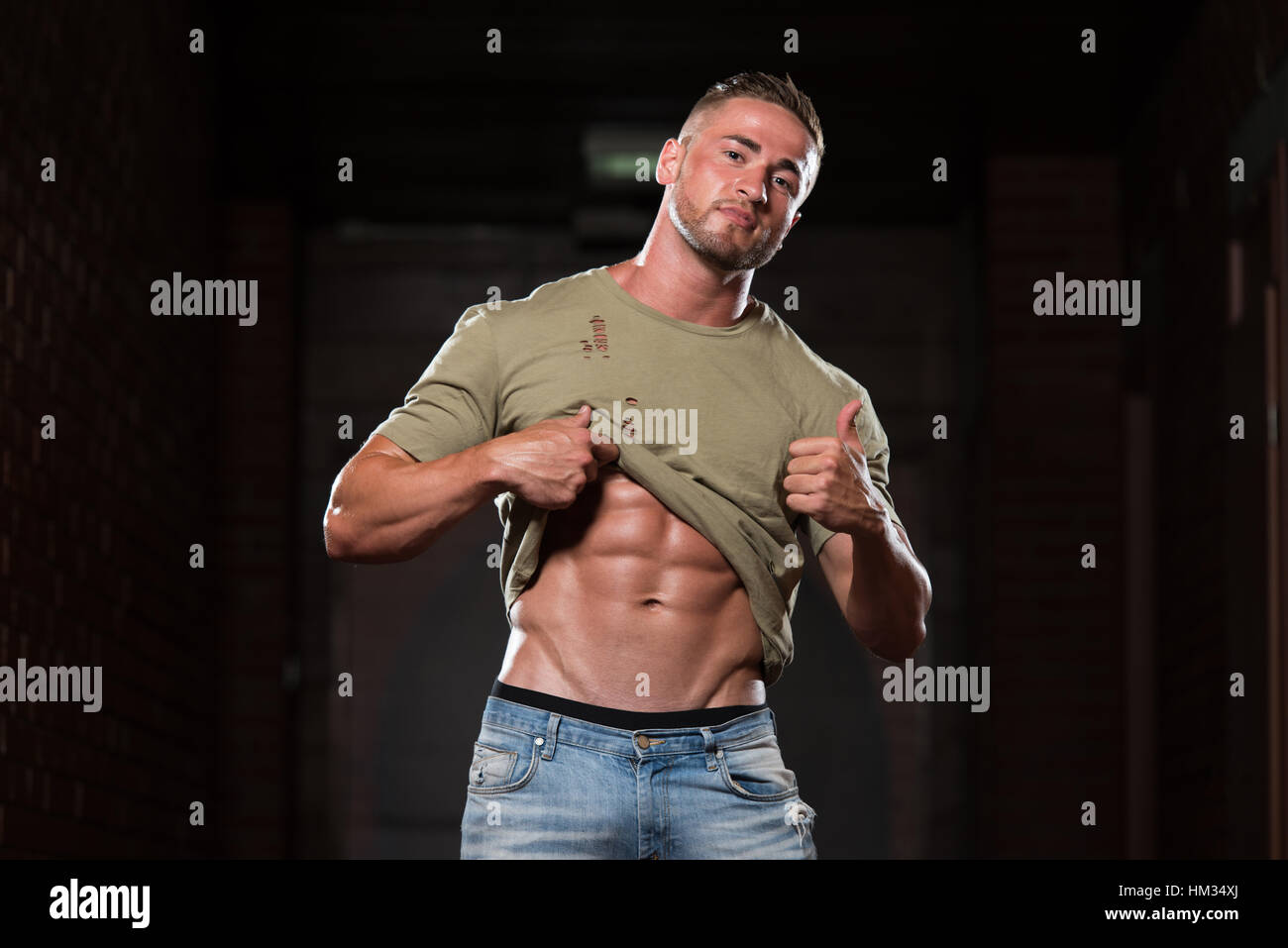 Portrait Of A Young Physically Fit Man In Jeans And T-shirt Showing His ...
