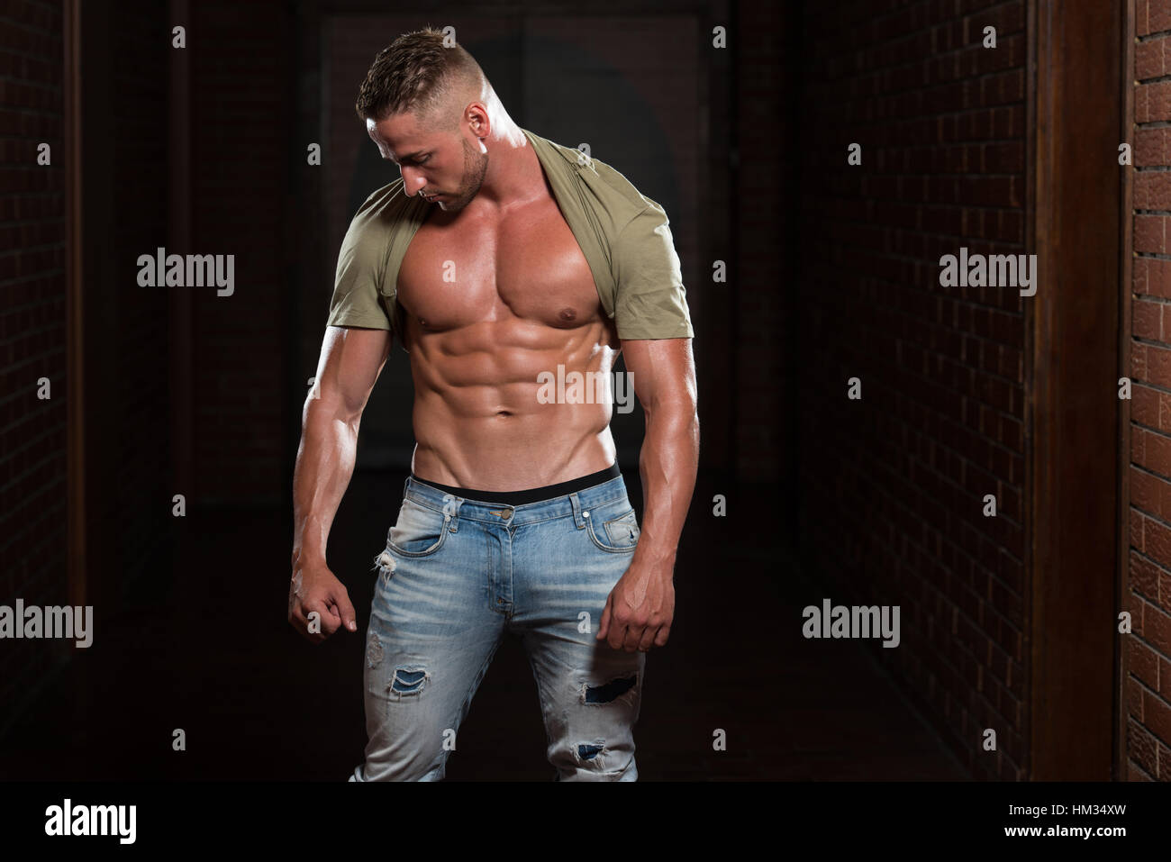 Healthy Young Man In Jeans And T-shirt Standing Strong In The Gym And ...